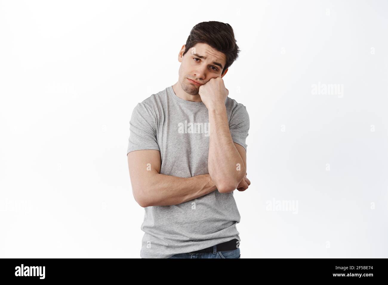 Portrait of bored and tired man wants to sleep, look with indiference ...