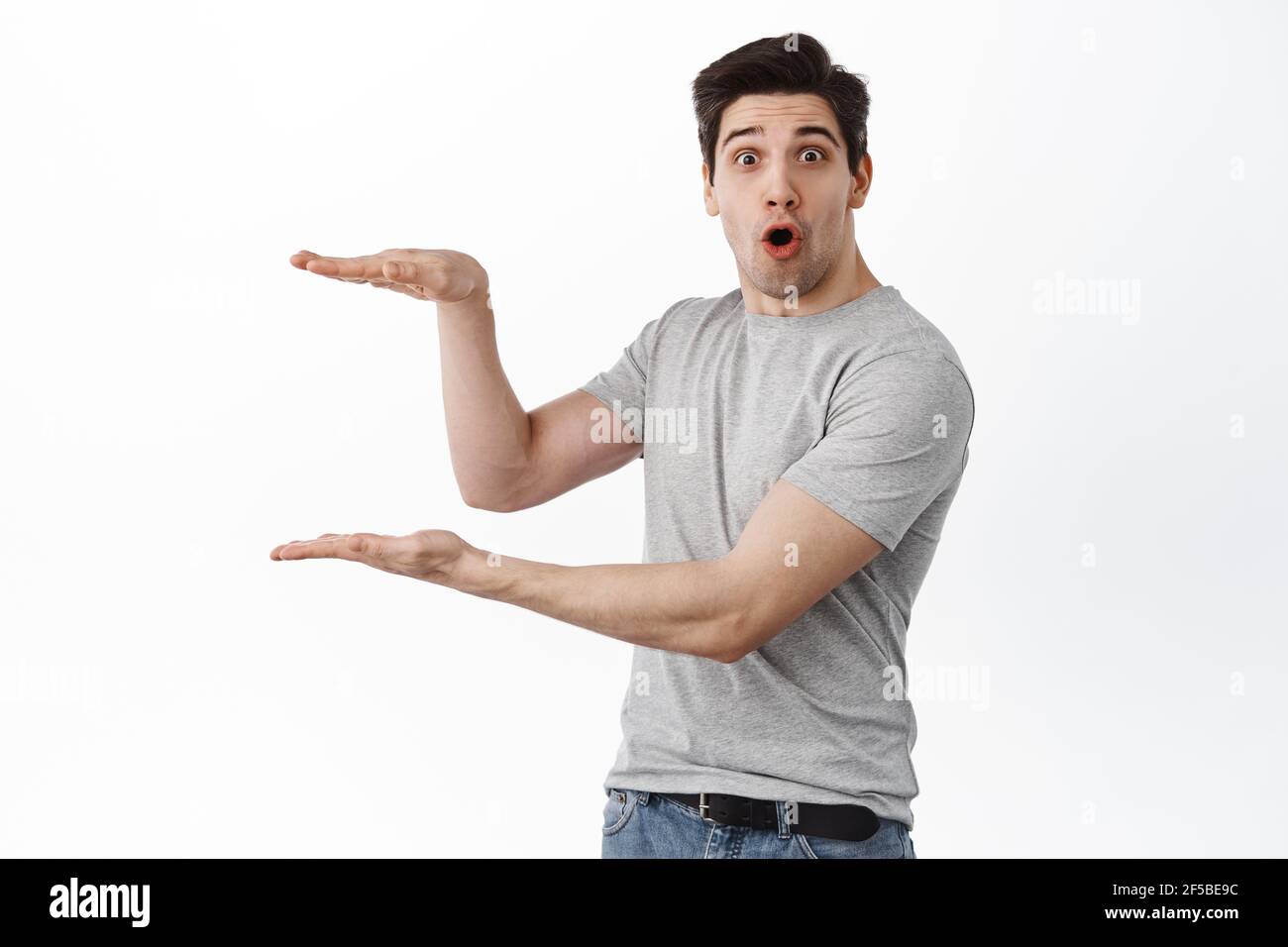 Place your product here. Surprised man holding object, empty copy space ... Place your product here. Surprised man holding object, empty copy space ...