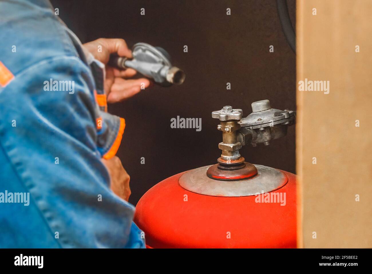 Worker man checks the connection system of the gas cylinder Stock Photo ...