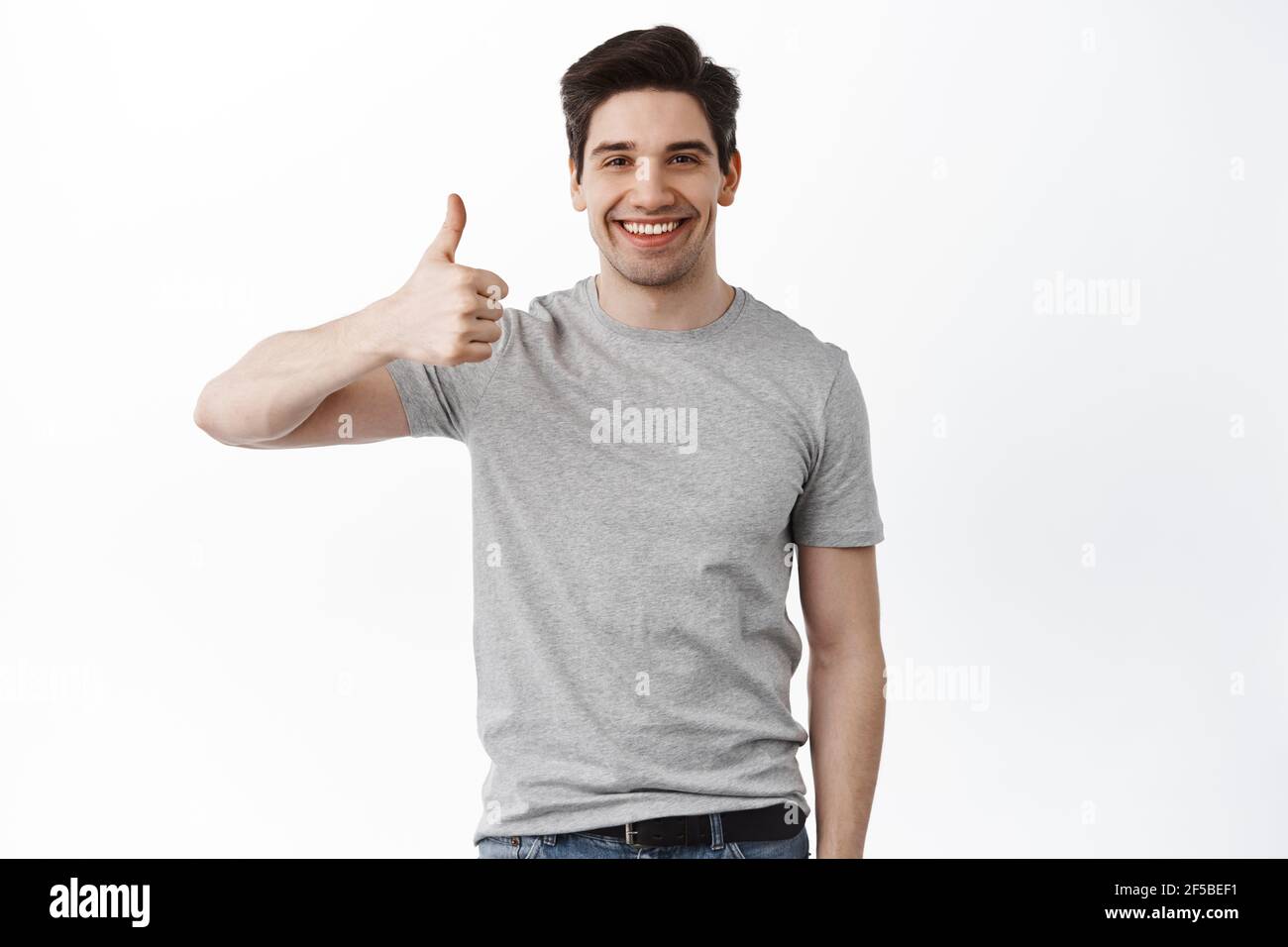 Good, well done. Smiling handsome man shows thumbs up with satisfied ...