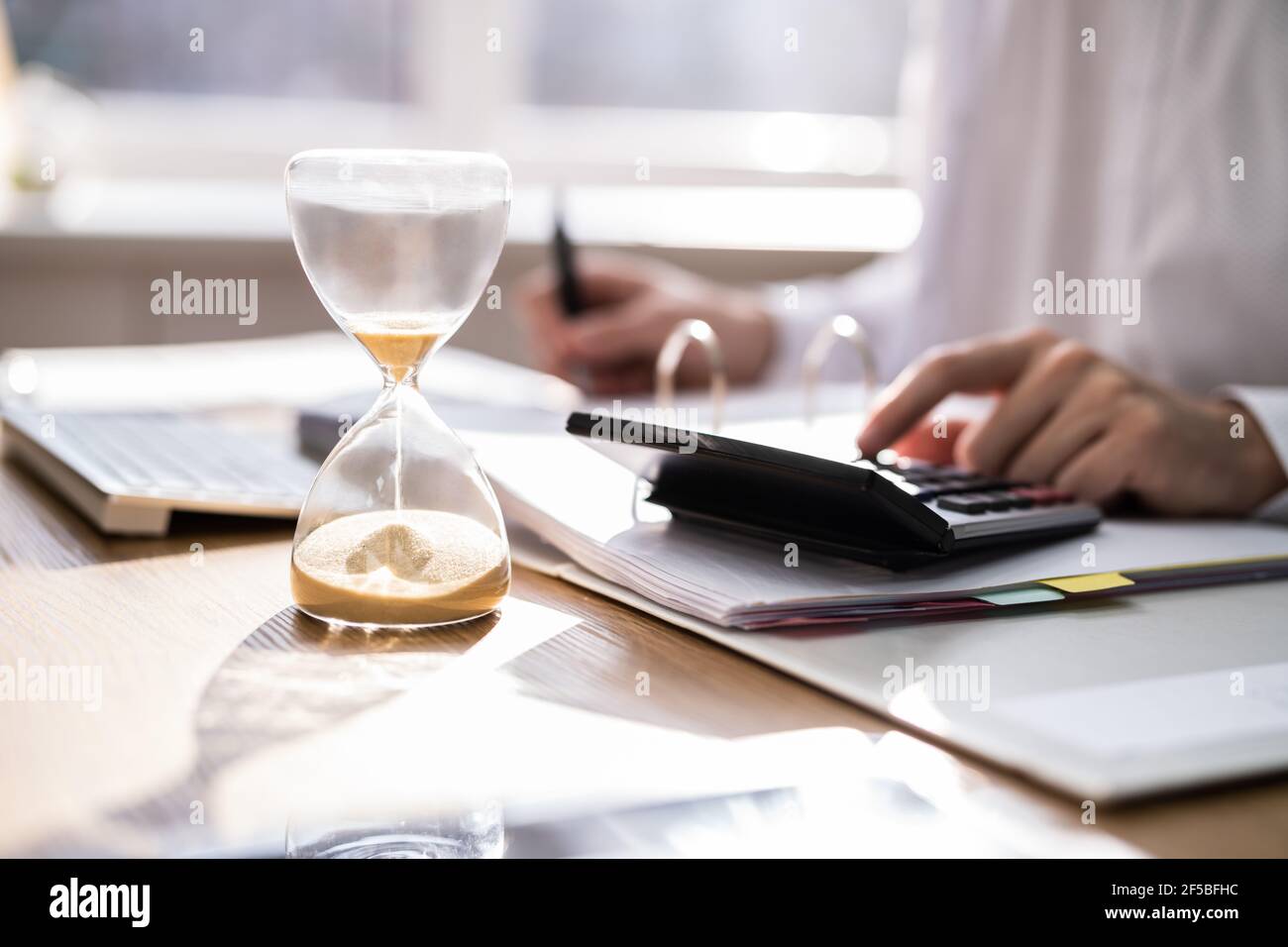 Accountant Calculating Invoice Bill In Time With Hourglass Stock Photo ...