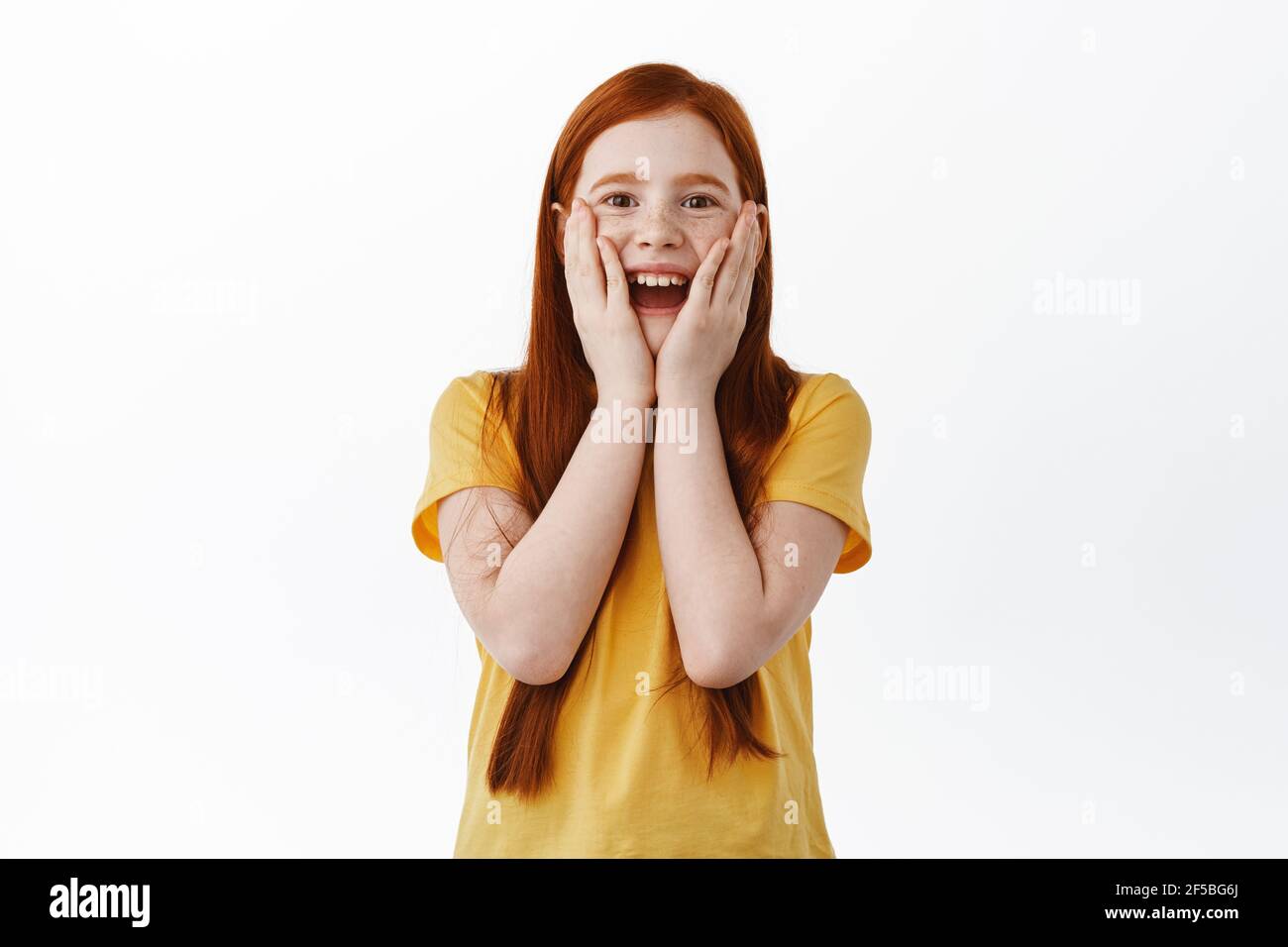 Surprised ginger girl with freckles checking out something awesome ...
