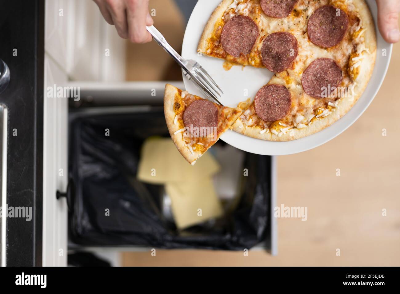 Food Waste. Throw Away Pizza In Dustbin Stock Photo - Alamy