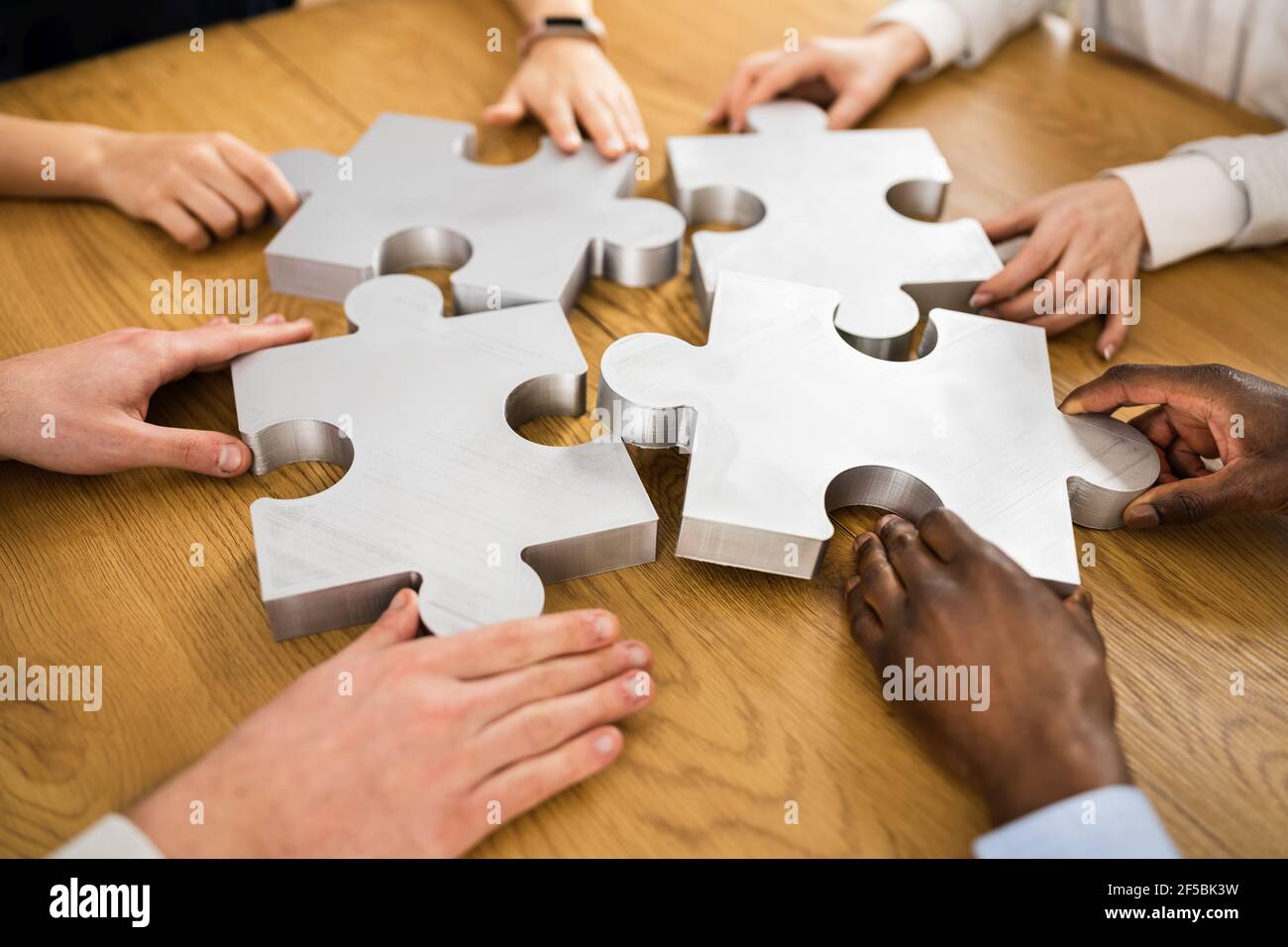 Teamwork Meeting Hands Solving Jigsaw Puzzle At Desk Stock Photo - Alamy