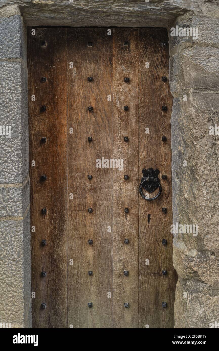 Vintage wooden door with stone frame, cast iron, ring shaped ...