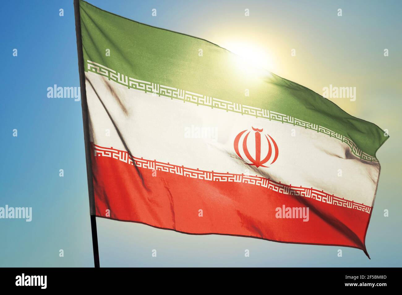Iran flag waving on the wind in front of sun Stock Photo - Alamy