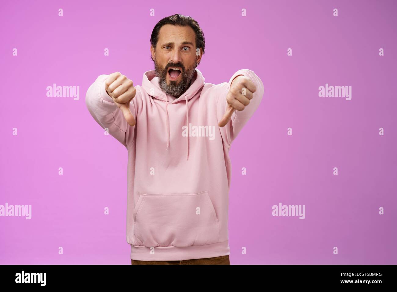 Extremely disappointed furious male customer swearing show thumbs down ...