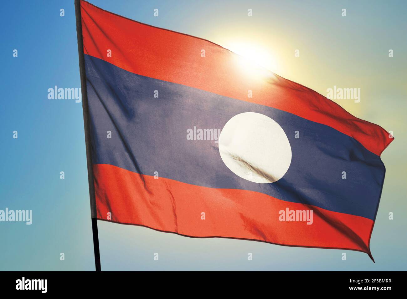 Laos flag in blue sky hi-res stock photography and images - Alamy