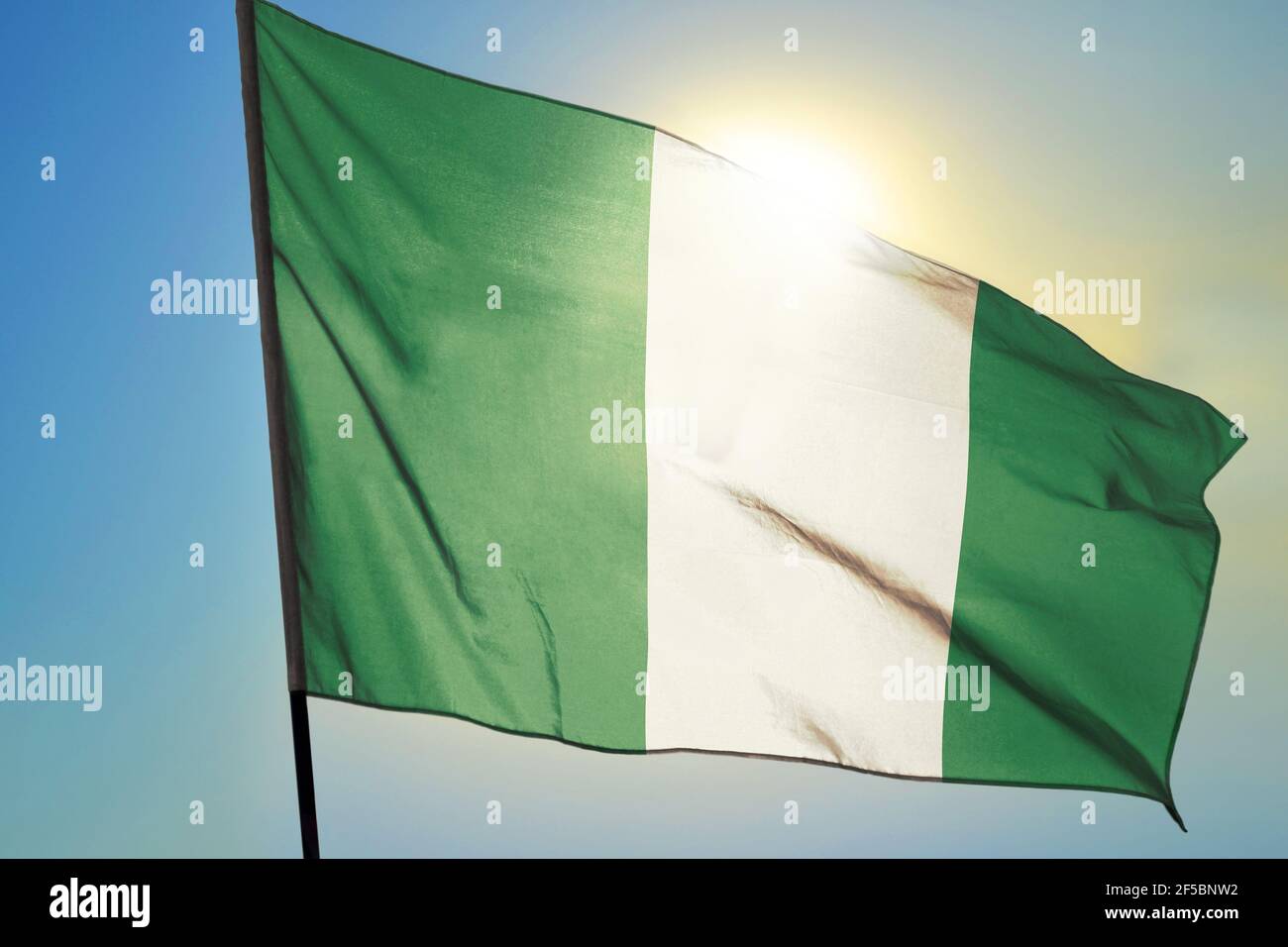 Nigeria flag waving on the wind in front of sun Stock Photo - Alamy