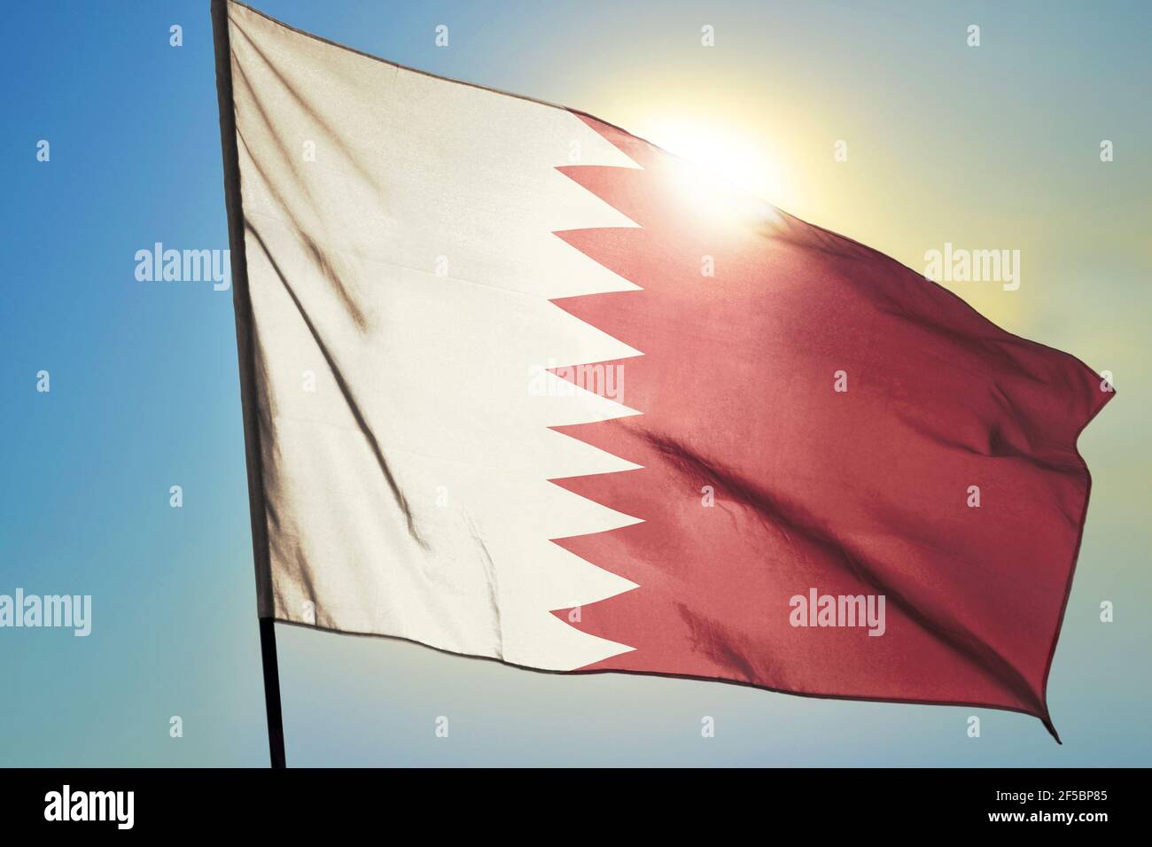 Qatar flag waving on the wind in front of sun Stock Photo - Alamy