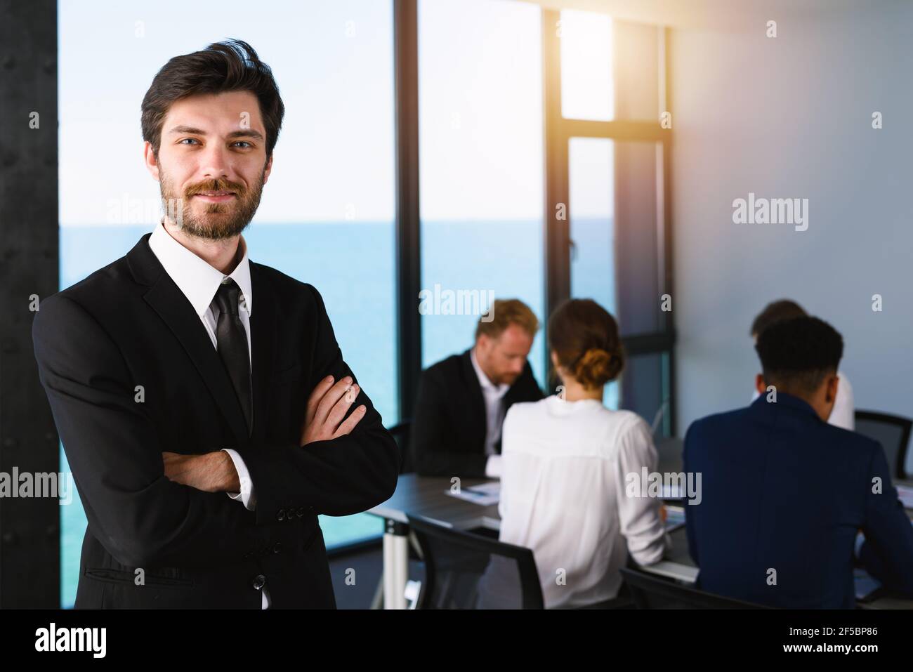Confident businessman in office with his teamwork. Concept of ...