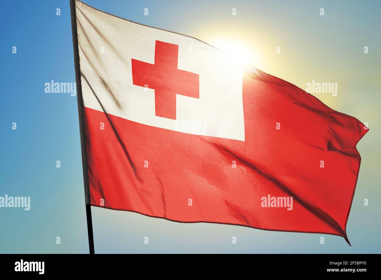 Tonga flag waving on the wind in front of sun Stock Photo - Alamy