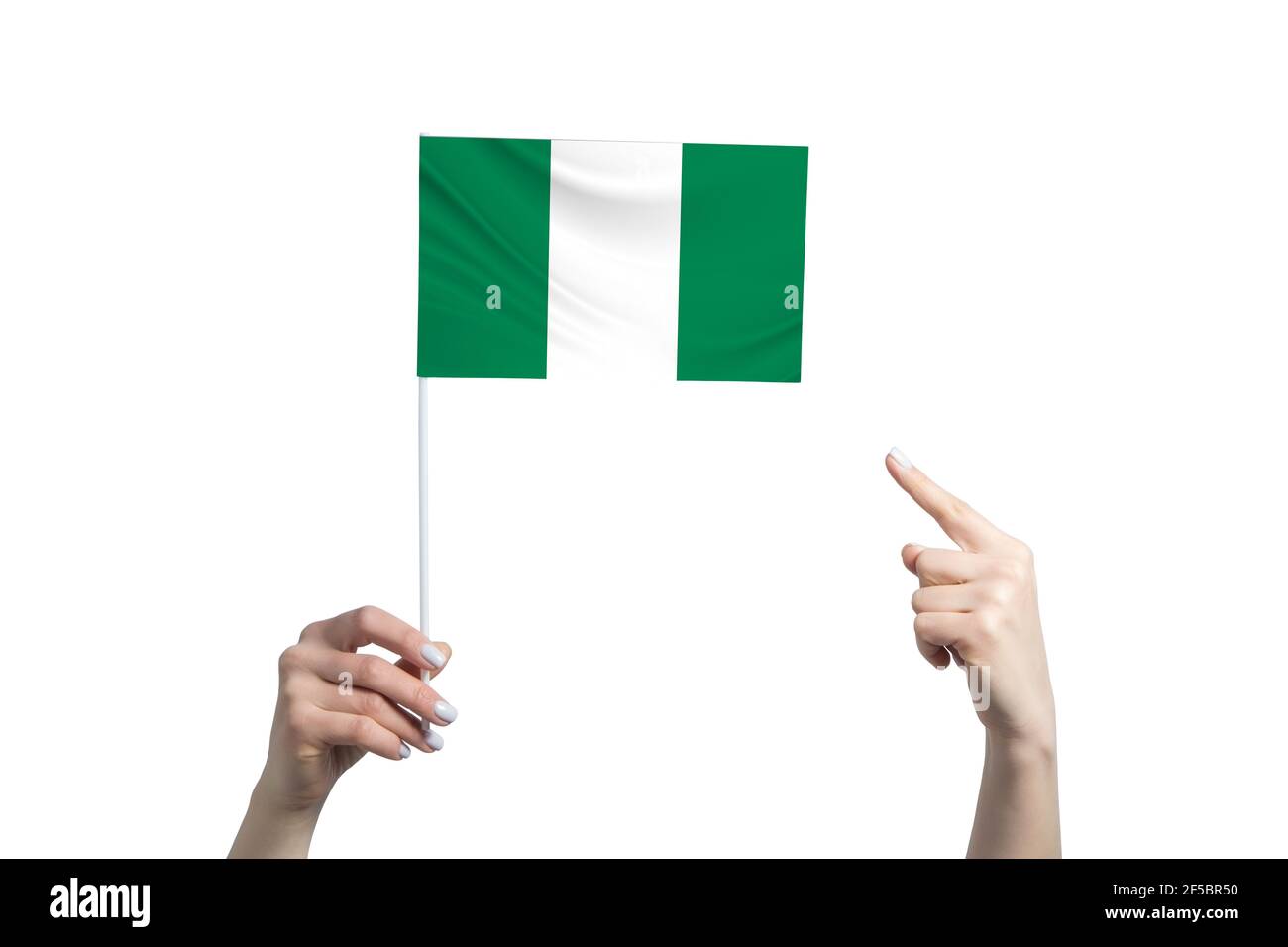 A beautiful female hand holds a Nigeria flag to which she shows the ...