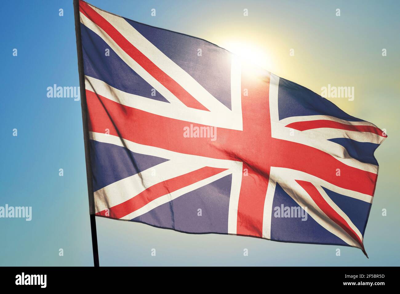 United Kingdom flag waving on the wind in front of sun Stock Photo - Alamy