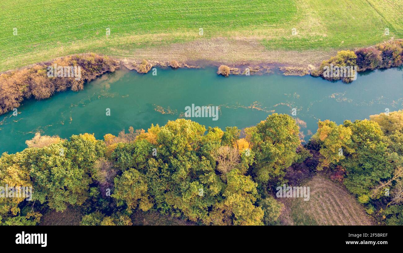 Drop down view of river flowing through fields after harvest Stock ...