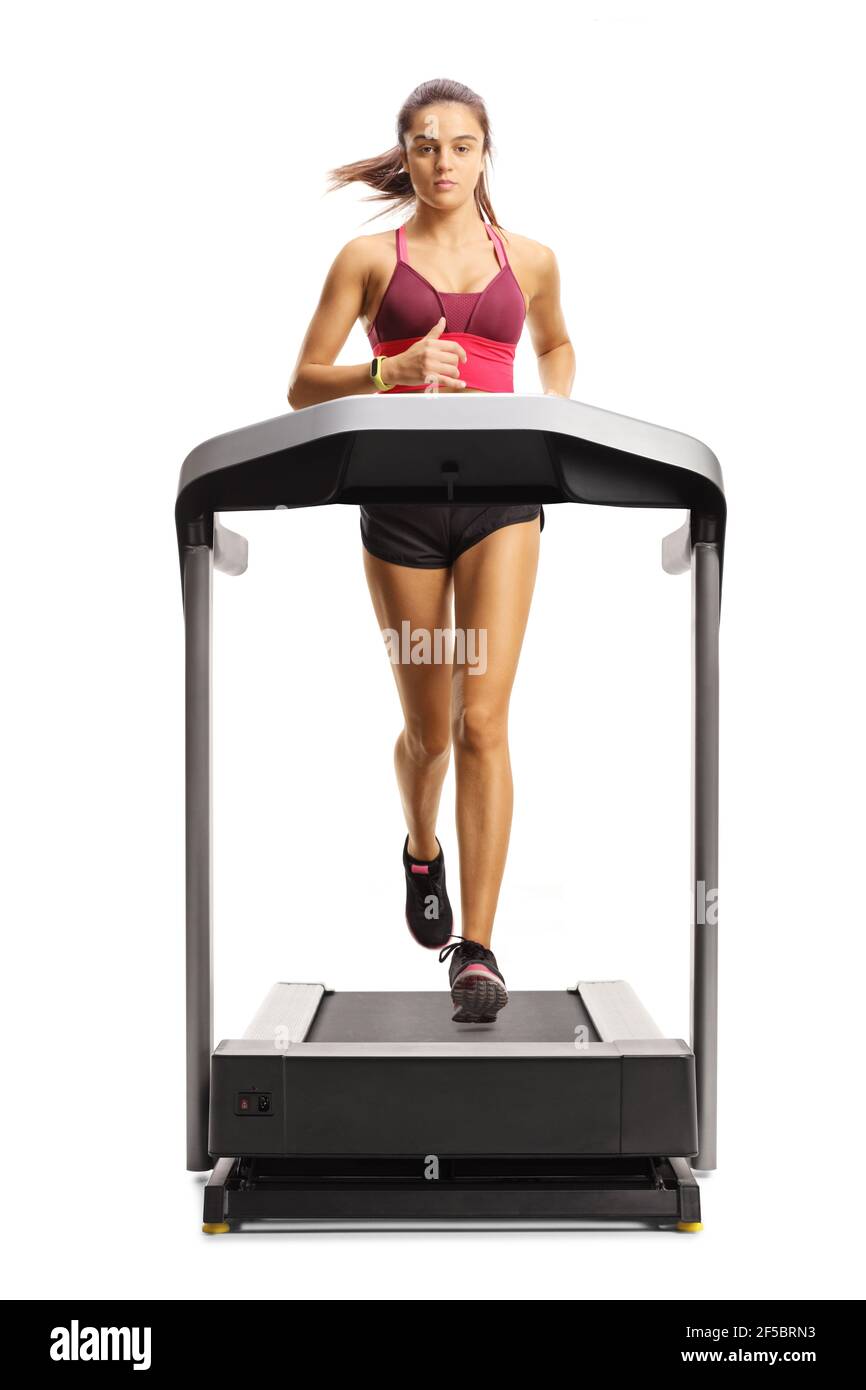 Young fit woman running on a treadmill and looking at camera isolated ...
