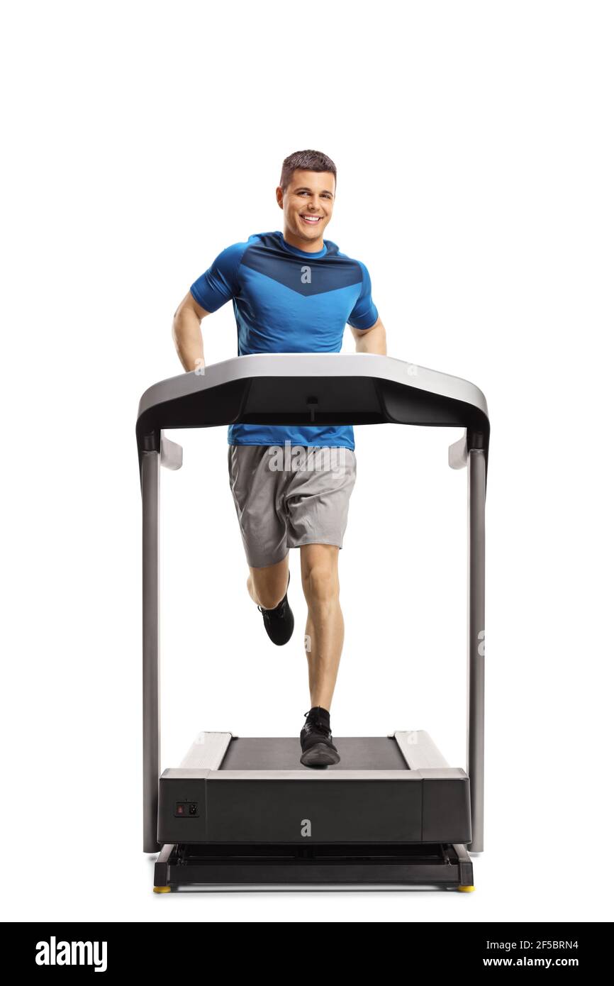 Full length portrait of a young man running on a treadmill and smiling ...