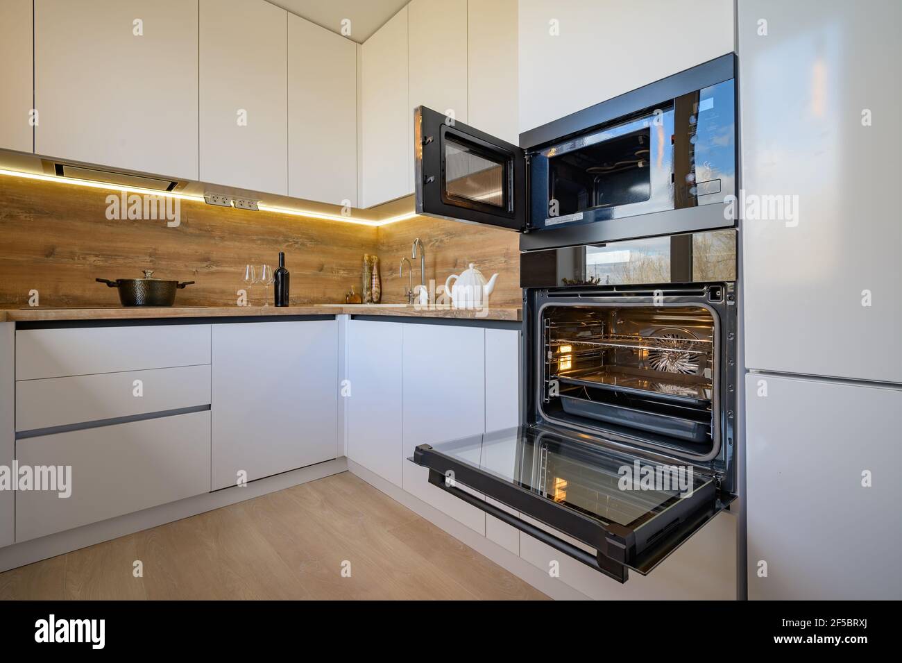 Modern white and beige wooden kitchen interior with oven opened Stock ...