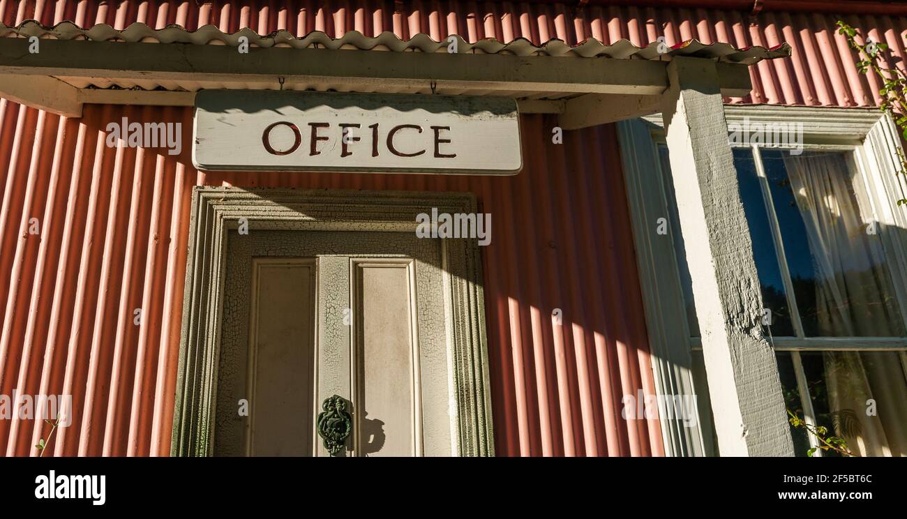 Over-door sign for office on exterior of rustic pink corrugated iron ...