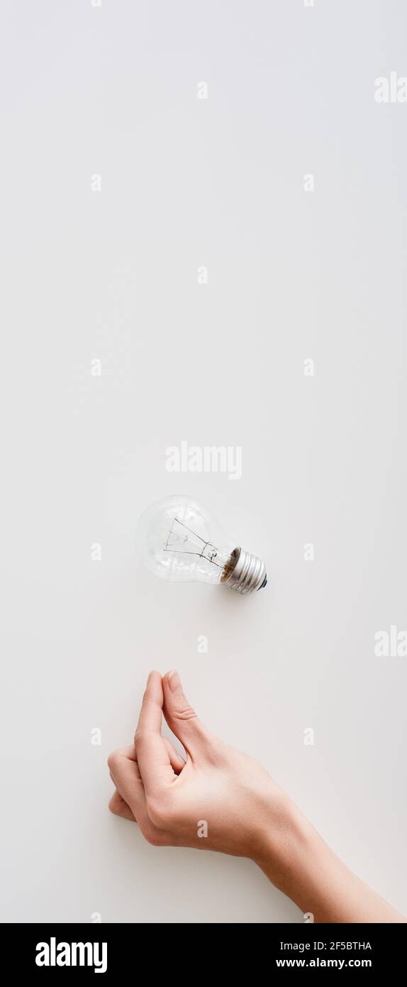Female hand near an incandescent light bulb Stock Photo - Alamy