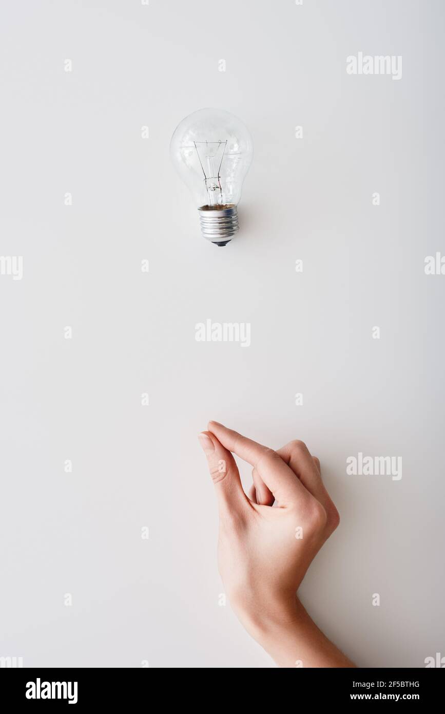 Female hand near an incandescent light bulb Stock Photo - Alamy