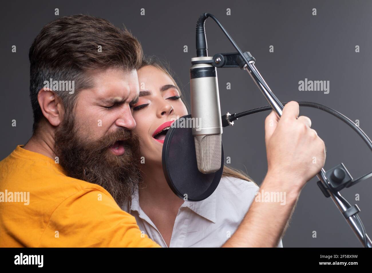 Karaoke singer couple. Man and woman singing with music microphone ...