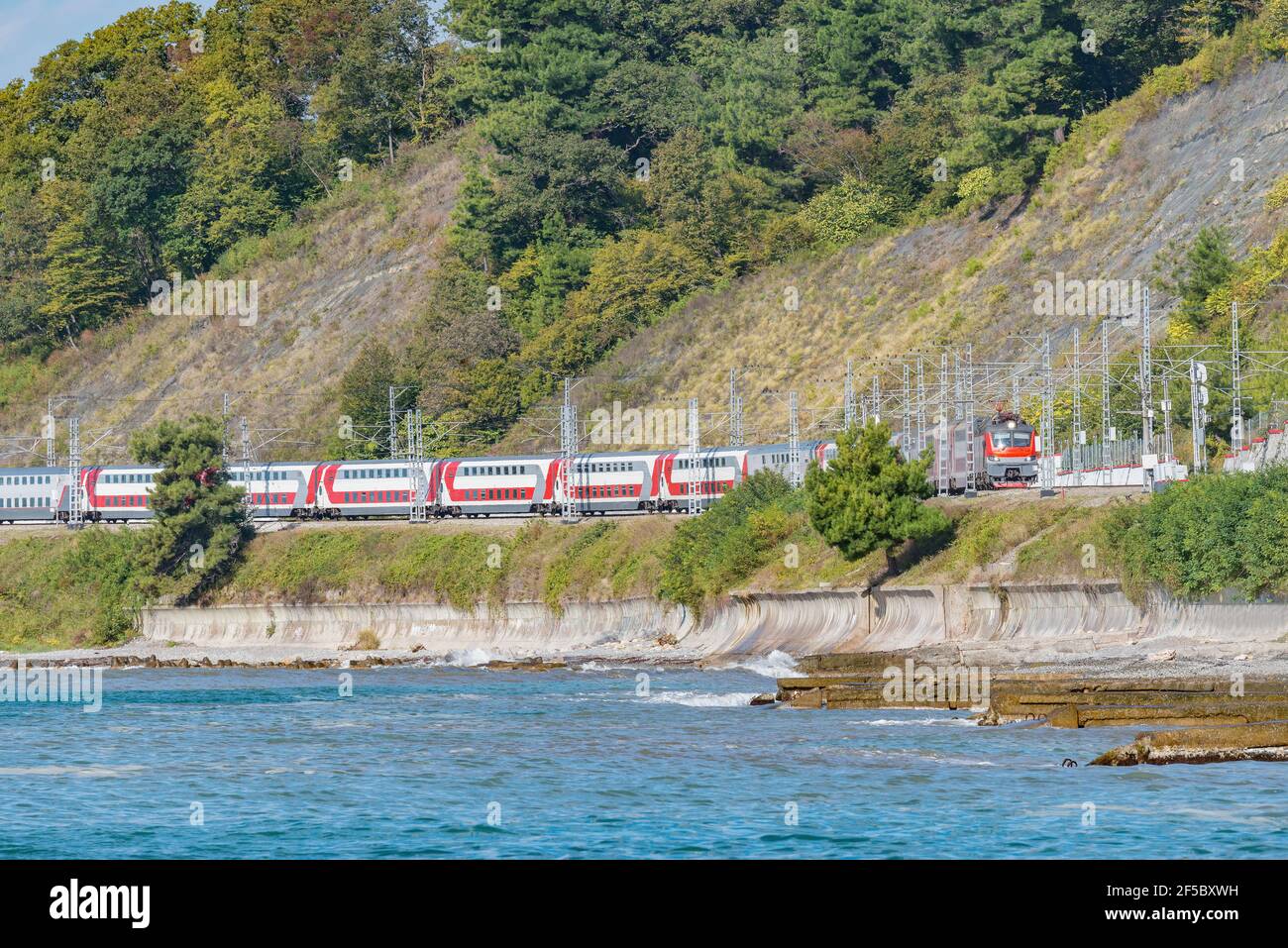 Passenger double deck train moves along Black sea coast. Sochi. Russia ...