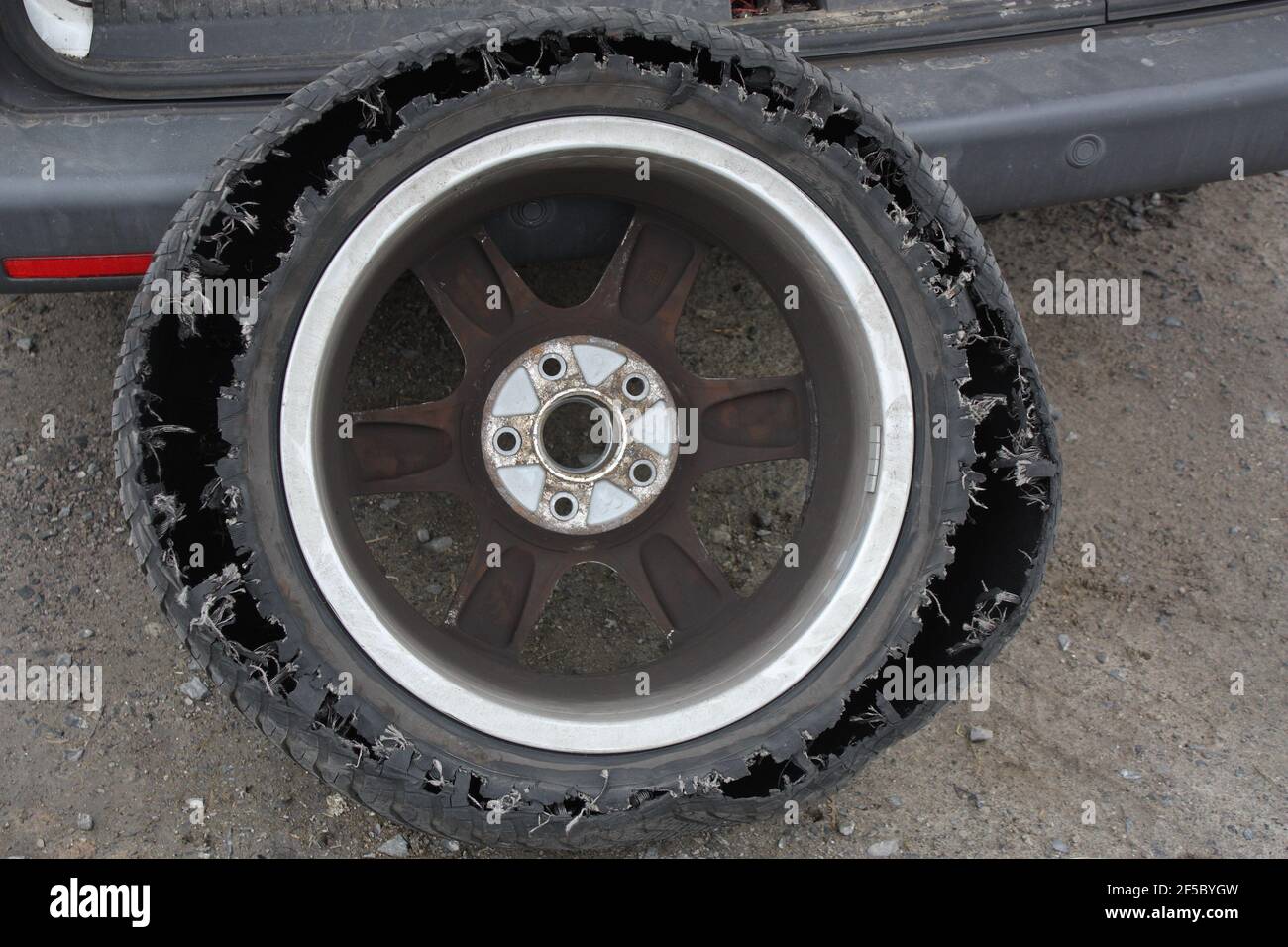Closeup of a badly damaged car tire on the ground at daytime Stock ...