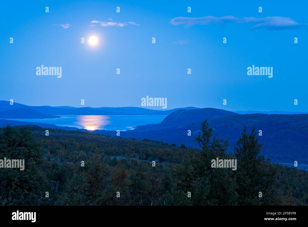 Full moon reflects in water surface of lake deep in Swedish arctic ...