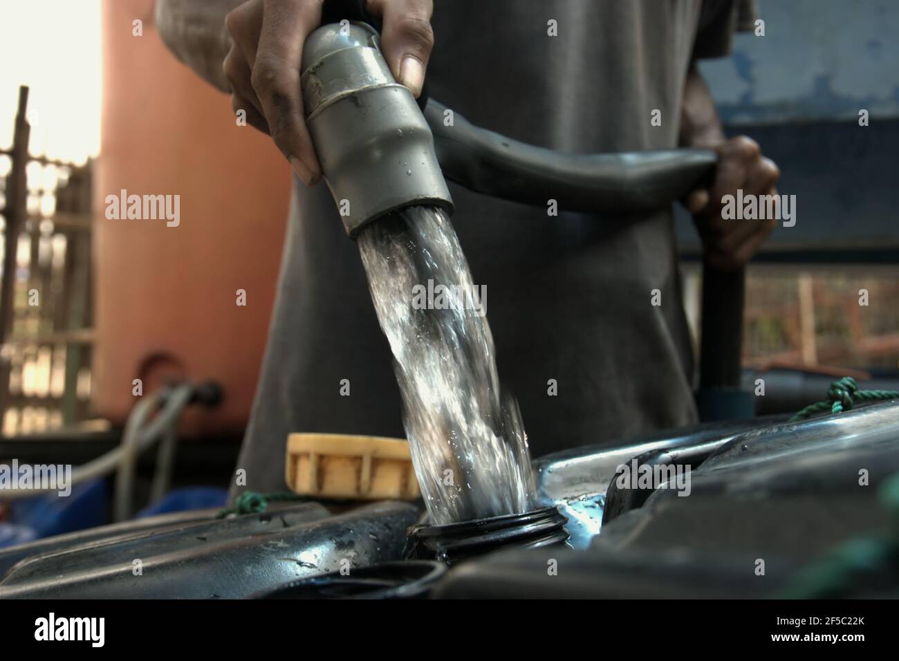 A water itinerant filling jerry cans with freshwater at a water filling ...