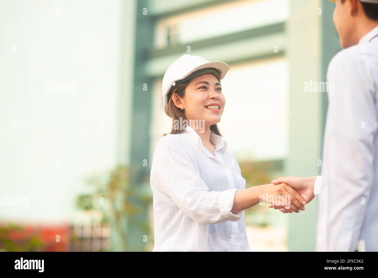 Worker smile teamwork shake hand Stock Photo - Alamy