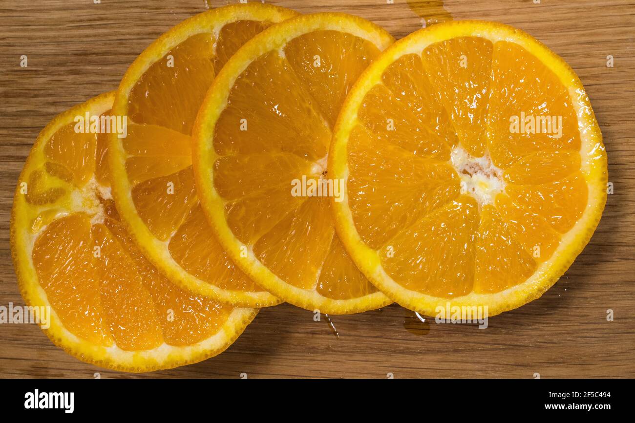 A sliced orange on a wooden table Stock Photo - Alamy