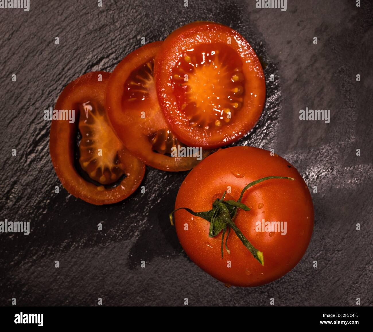 Freshly sliced tomato slices - top down view Stock Photo - Alamy