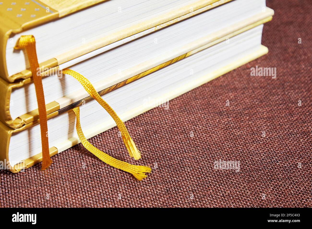 Heap of vintage yellow hardcovered books with bookmarks on a bookshelf ...