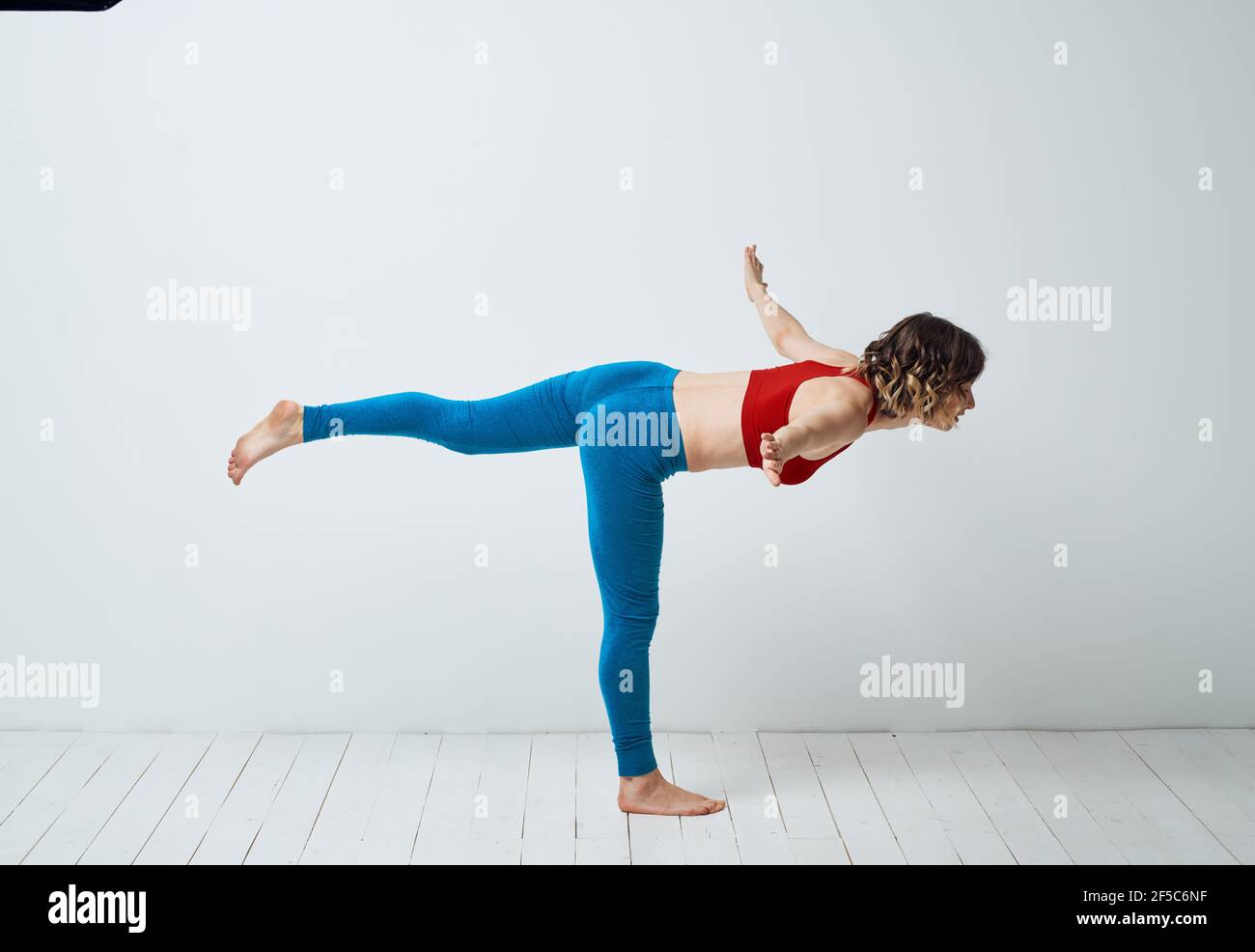 balance woman stands on one leg In a bright room and leggings Yoga ...