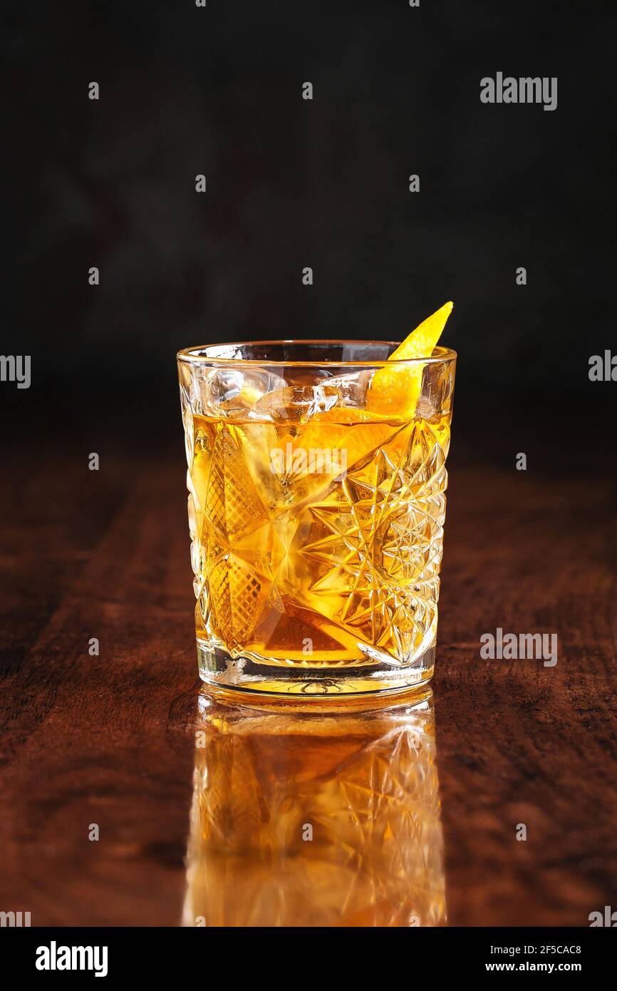 Whiskey cocktail on wooden table with reflection Stock Photo - Alamy