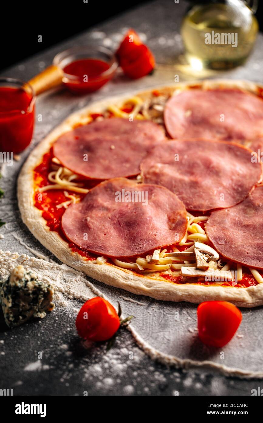 Prepared dough base for pizza with toppings Stock Photo - Alamy