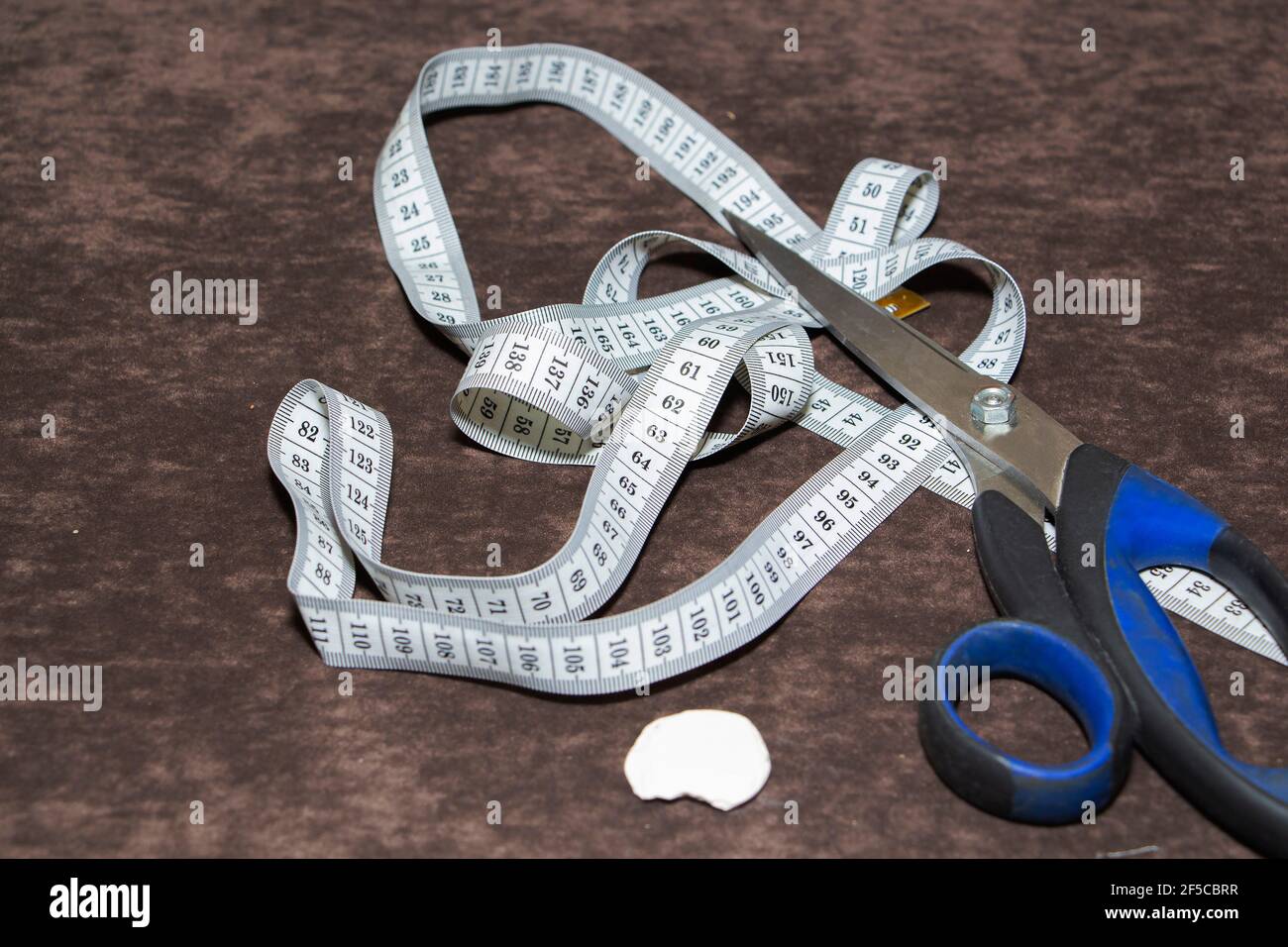 Tailor's desktop background, with tape measure, chalk and scissors ...