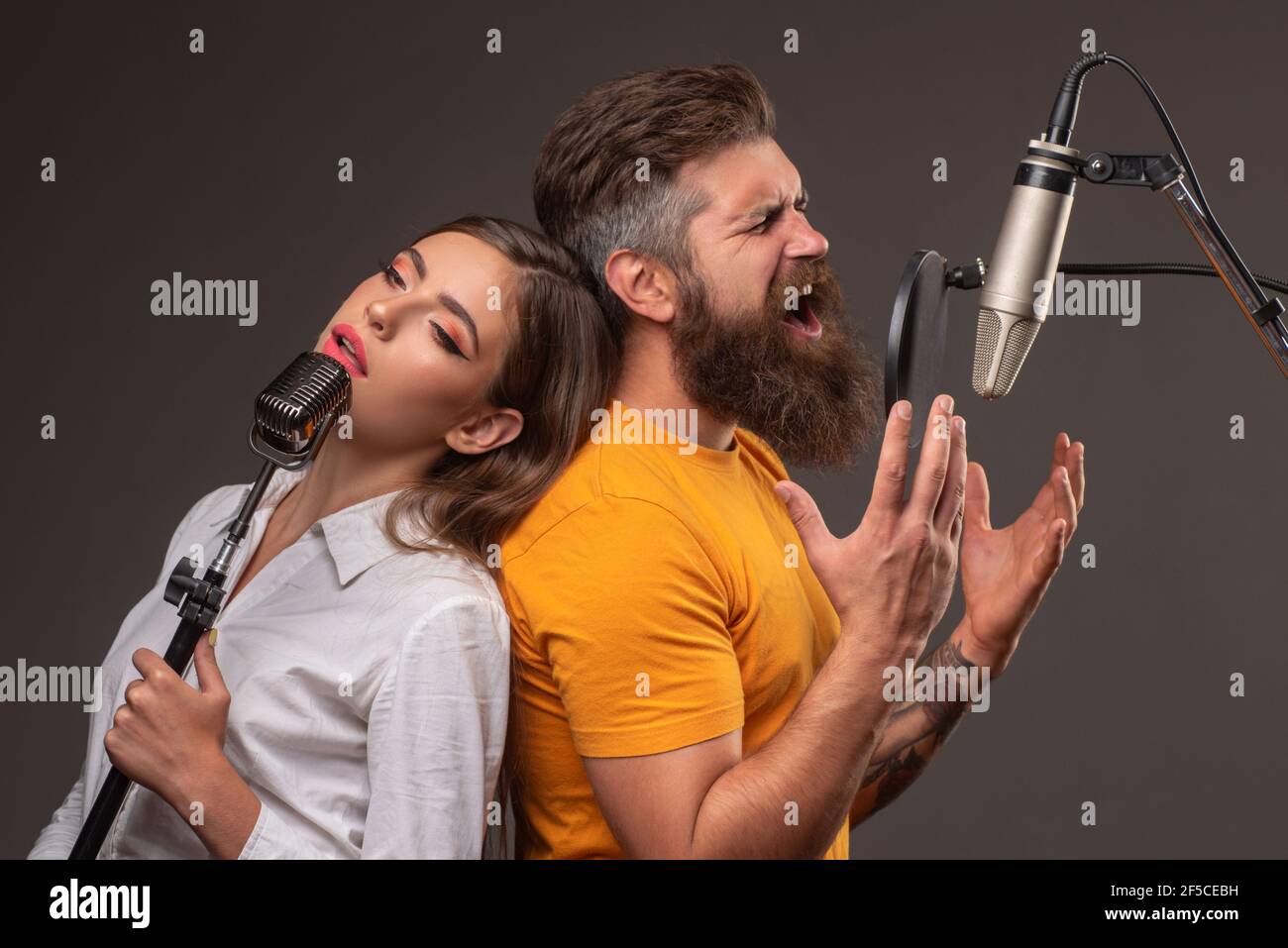 Singer couple singing rock. Sound producer recording song in a music ...