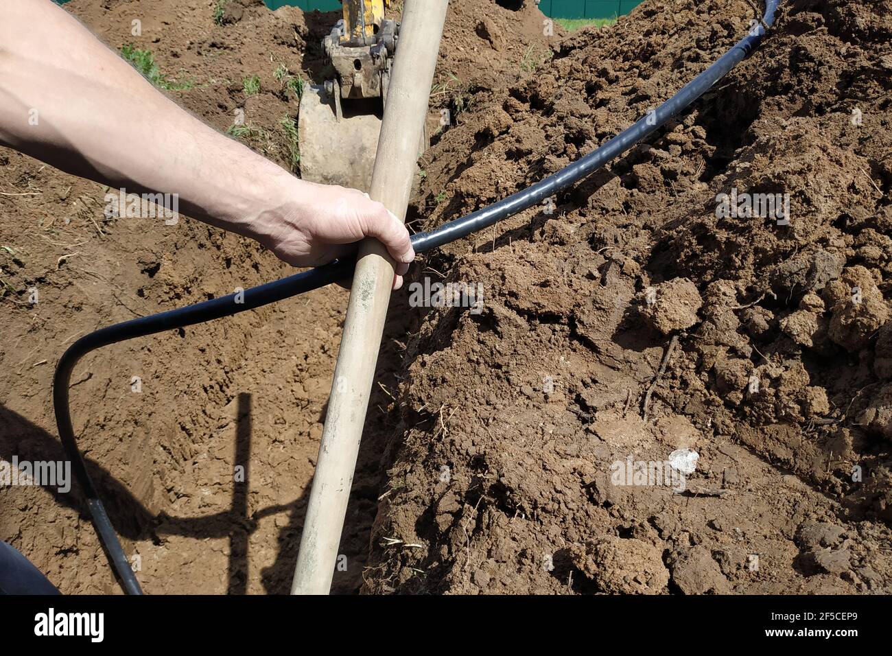 Wiring of an electric cable on the dug trench, supply of the electric ...