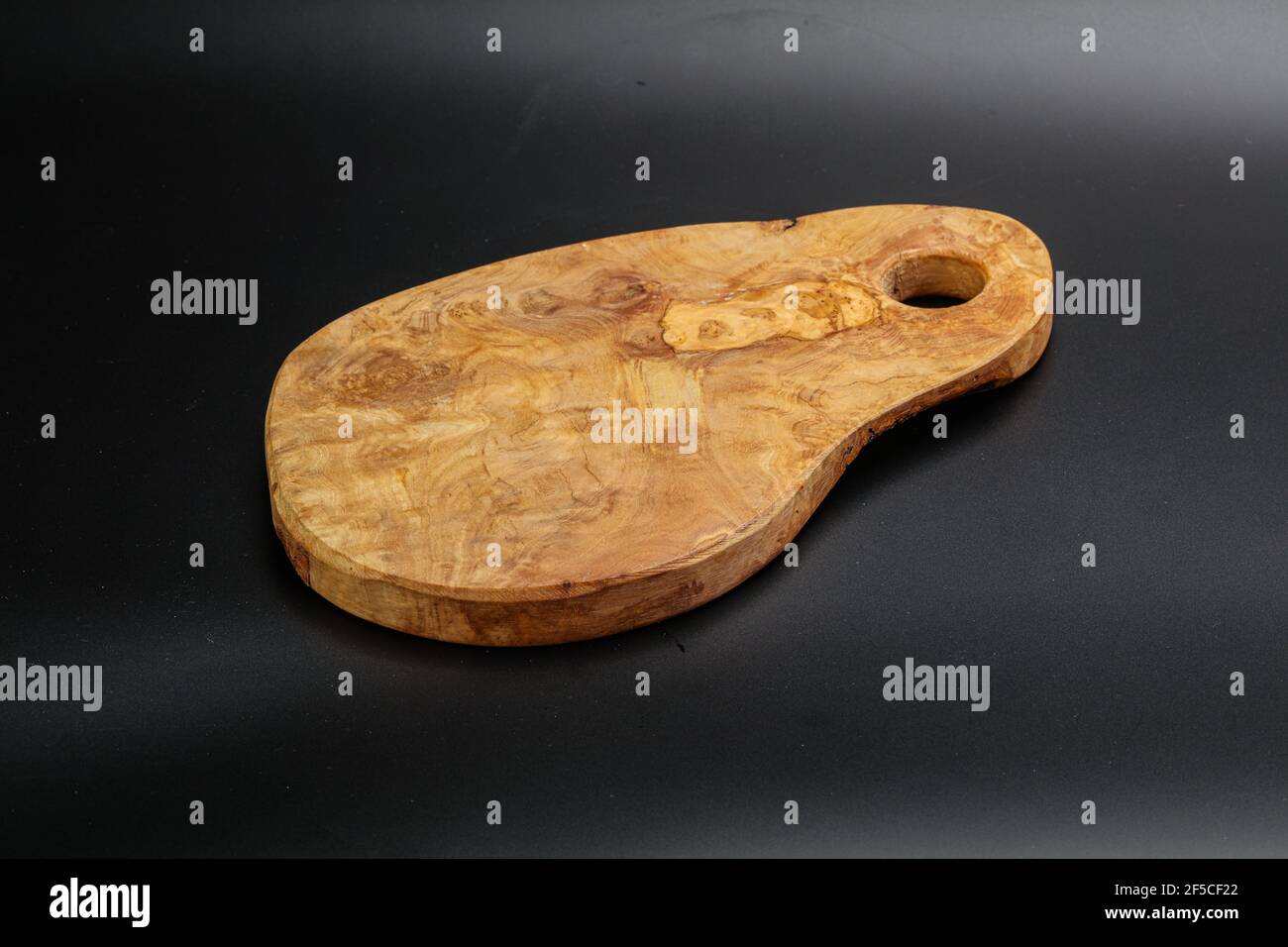 Olive tree board for kitchen over black background Stock Photo - Alamy