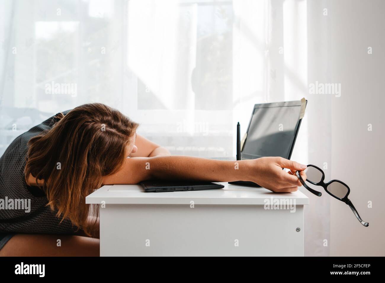Young woman sleeping in the workplace. Fatigue and overload in office ...