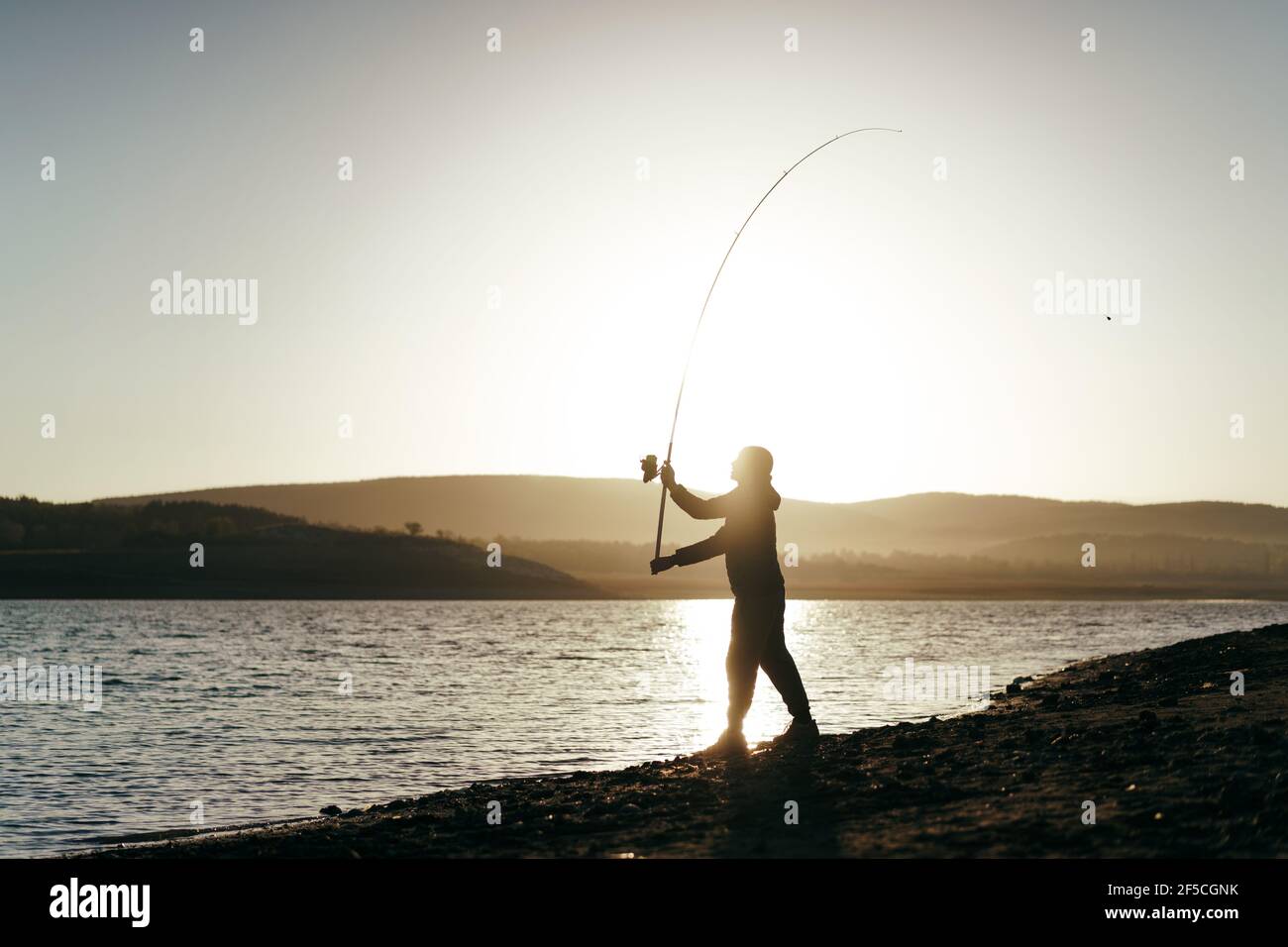 Fisherman with rod fishing on the lake Stock Photo - Alamy