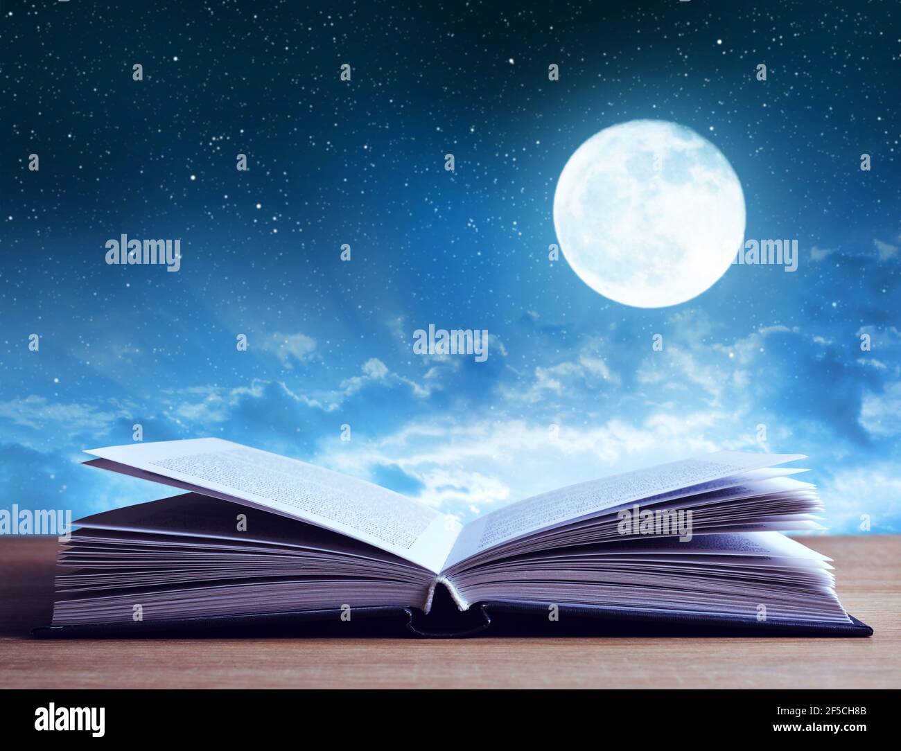 Open book on wooden plank night sky with moon in the background Stock ...