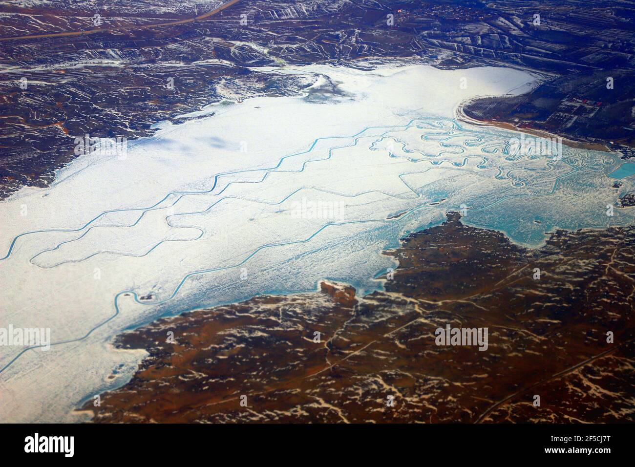 Altay, China. 26th Mar, 2021. ALTAY, CHINA - MARCH 25, 2021 - An aerial view of a frozen river ...
