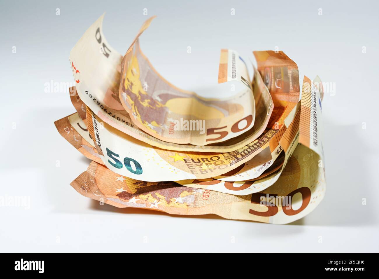 Crumpled 50 euro notes layered on top of each other in a pile, concept ...