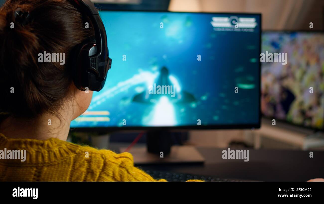 Back view of professional online gamer woman playing shooter game. Pro ...