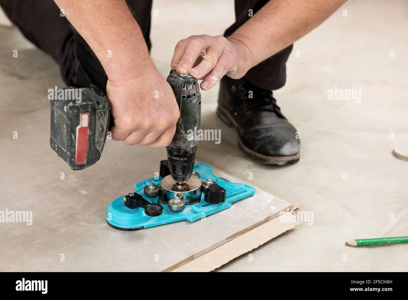 A tiler uses a caliper with a suction cup to drill holes in the ceramic ...