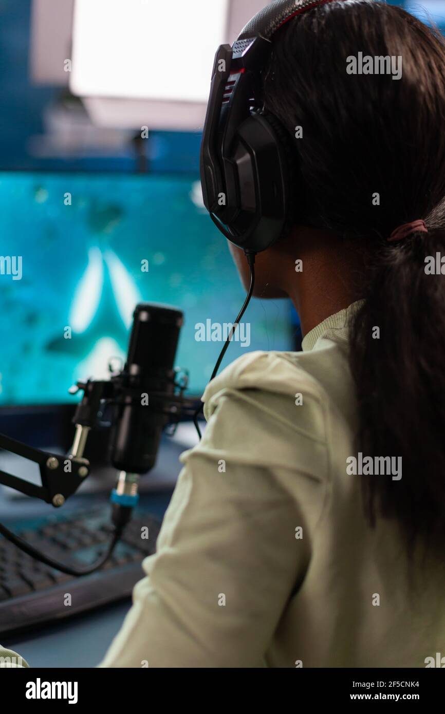 Dark skinned online e sport player talking into microphone with ...