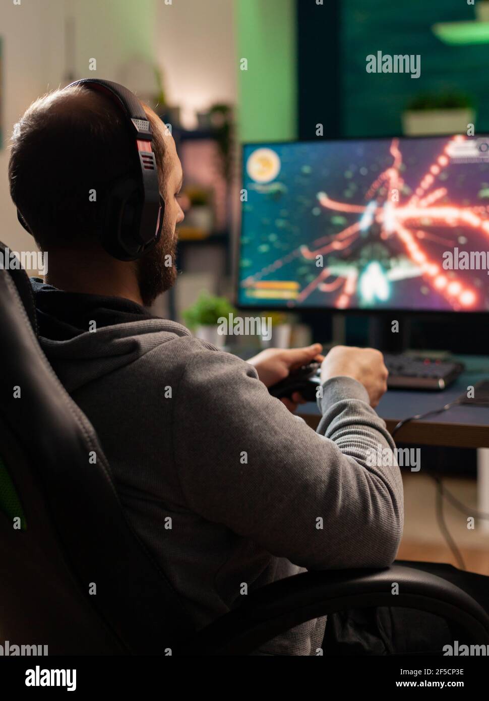 Cyber man with headset playing game in competition holding wireless ...